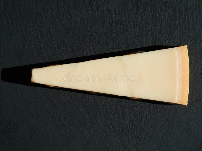 The Triangular Piece of Cheese on a Dark Surface. Stock Photo - Image ...