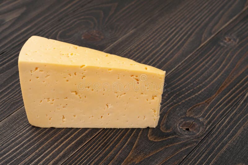 The Triangular Piece of Cheese on a Dark Wooden Surface Stock Image ...