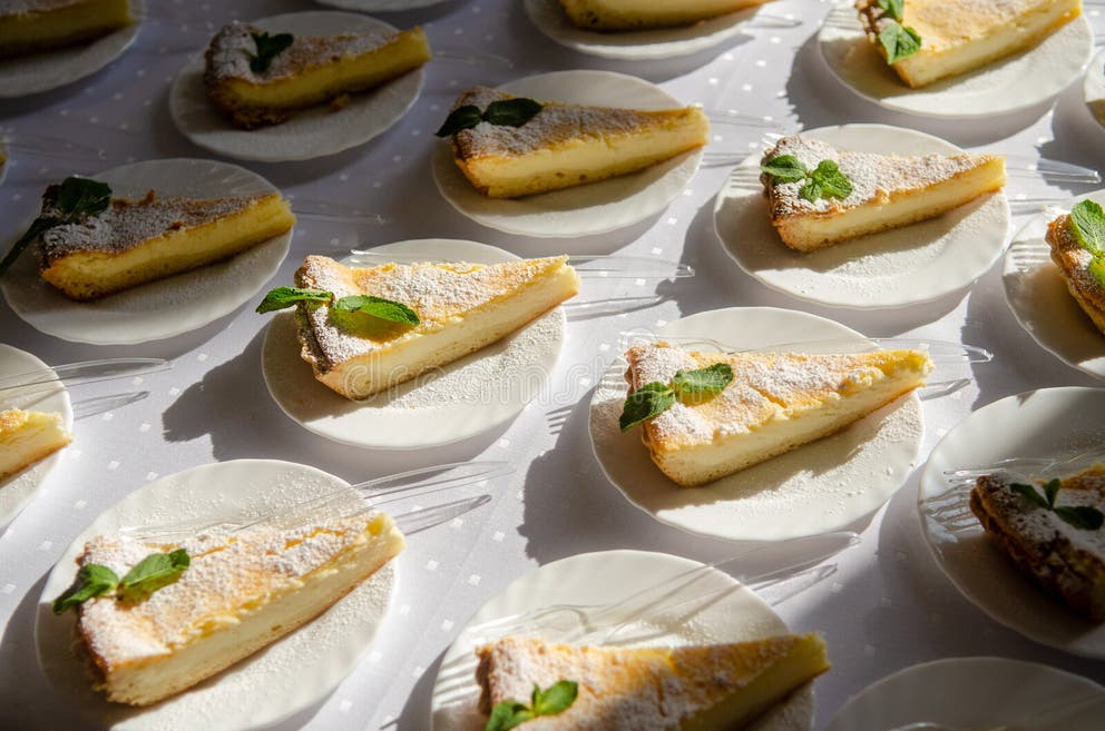 Triangular Pieces of Cheesecake with Mint on White Plates with Forks ...