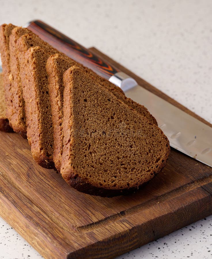 Triangular Rye Piece of Bread on a Wooden Cutting Board Stock Photo ...