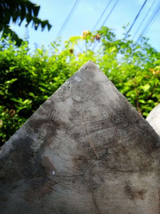 Triangular Stone with Trees in the Background Stock Photo - Image of ...