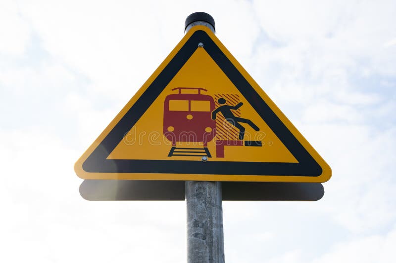 Triangular Yellow Warning Sign on the Platform Meaning Beware of ...