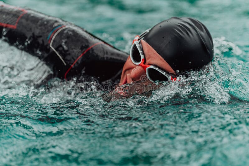 A Triathlete in a Professional Swimming Suit Trains on the River while ...