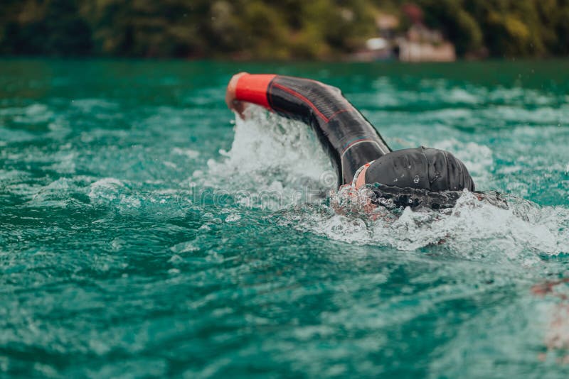 A Triathlete in a Professional Swimming Suit Trains on the River while ...