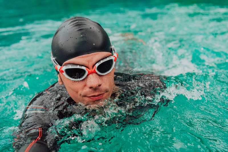 A Triathlete in a Professional Swimming Suit Trains on the River while ...