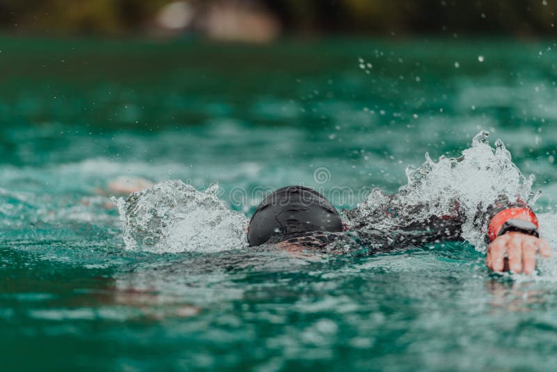 A Triathlete in a Professional Swimming Suit Trains on the River while ...