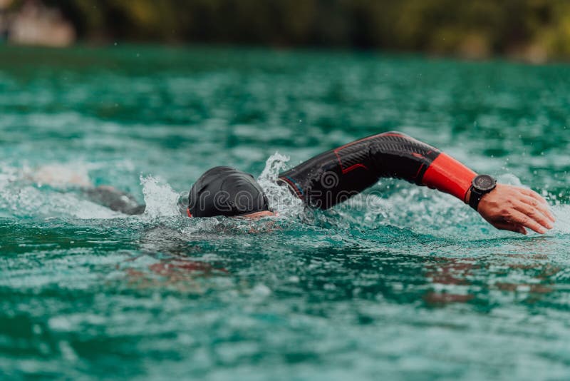 A Triathlete in a Professional Swimming Suit Trains on the River while ...