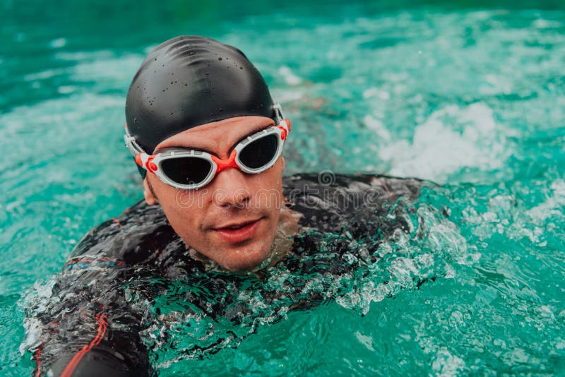 A Triathlete in a Professional Swimming Suit Trains on the River while ...