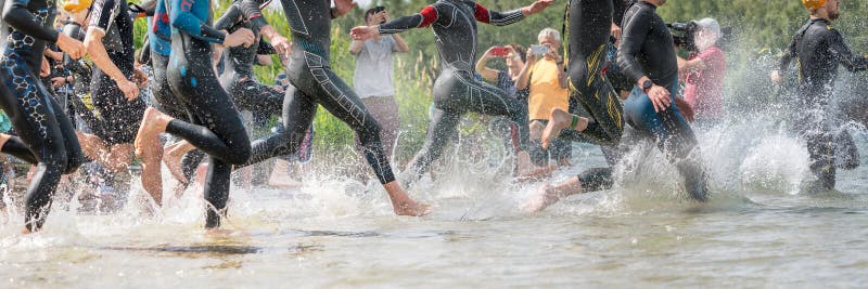 Triathletes in Wetsuits Running into a Lake at a Triathlon Competition ...