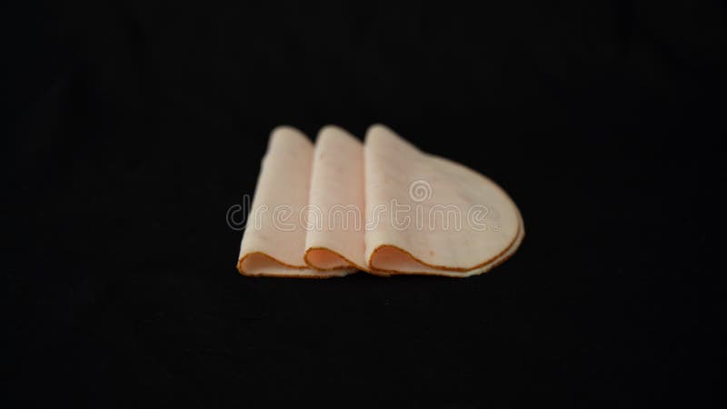 Trio of Poultry Ham Slice, Folded in Half, on a Black Background Stock ...
