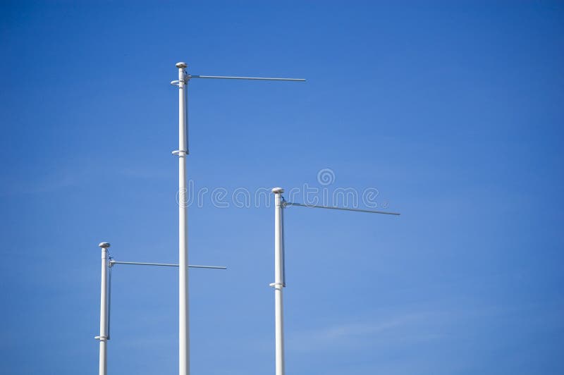 Triple Empty Flagpole Against Blue Sky Stock Image - Image of clear ...