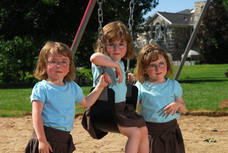 Triplets on the swingset stock image. Image of triplets - 15419087