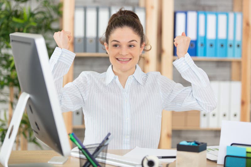 Triumphant Young Secretary Sat at Computer Desk Stock Photo - Image of ...