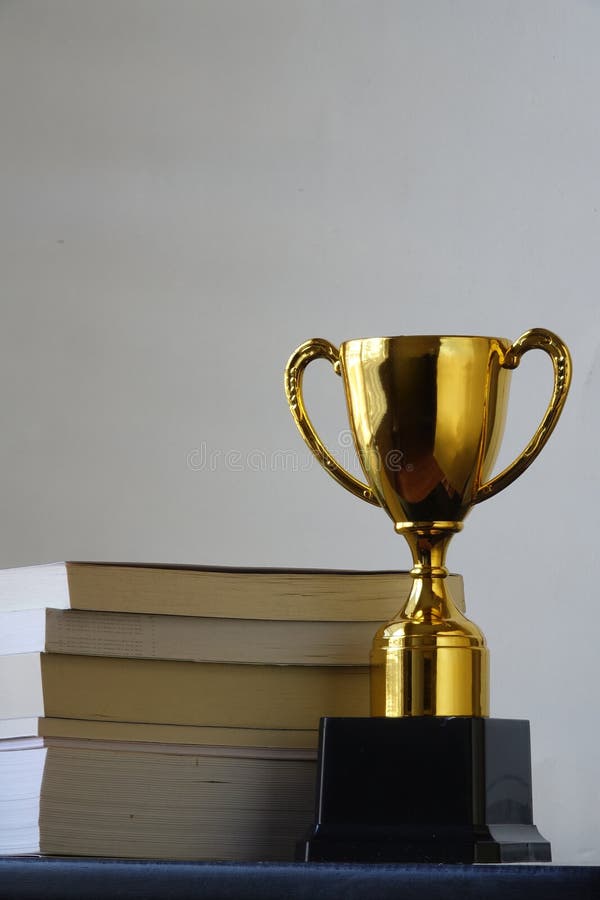 Trophy Symbolizes Winning through Reading Books Stock Image - Image of ...