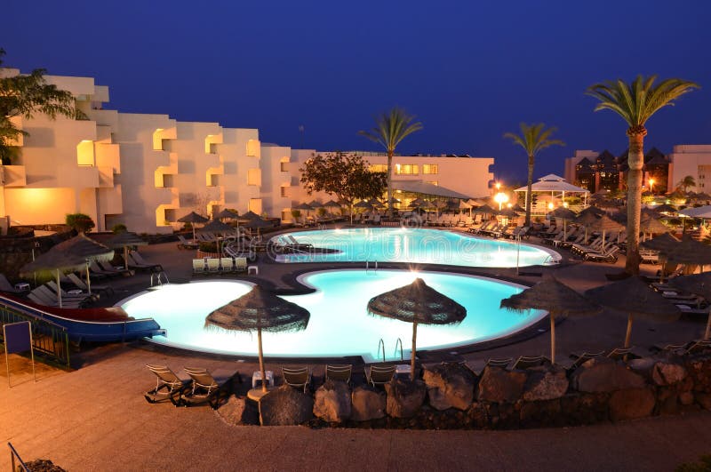 Tropical pool by night stock photo. Image of parasol - 24274796