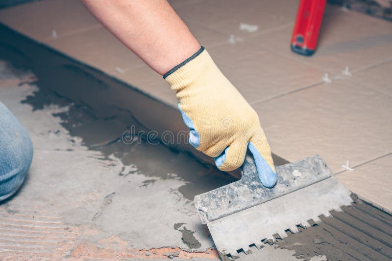 Notched Trowel And Worker Hands On Tile Stock Photo - Image of ...