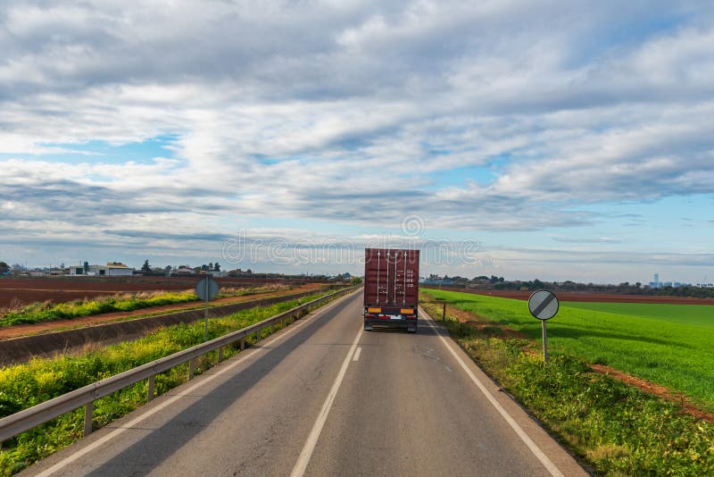 Truck with a Container Circulating on a Conventional Road Next To ...
