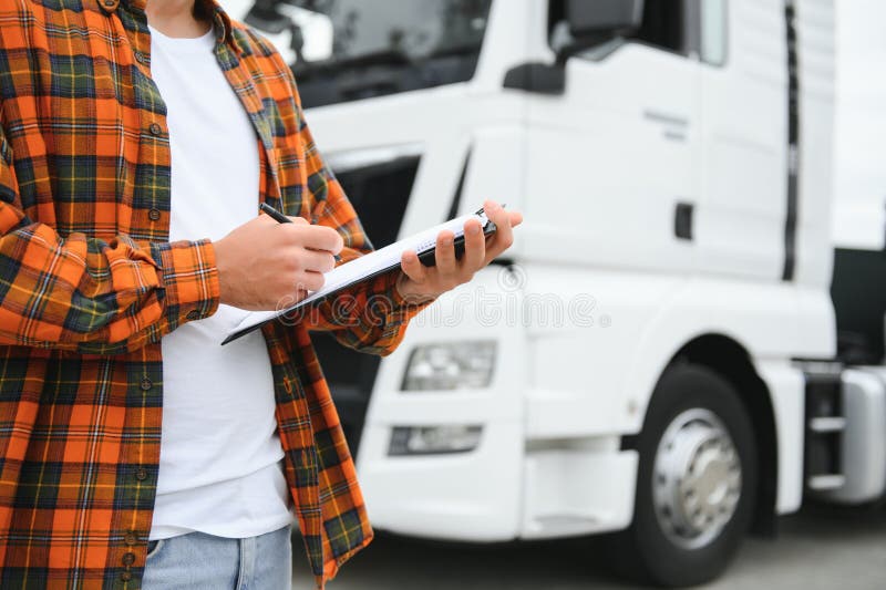 Truck Driver Checking Shipment List while Standing on Parking Lot of ...