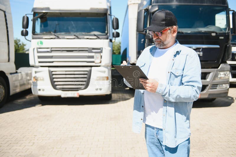 Truck Driver Checking Shipment List while Standing on Parking Lot of ...