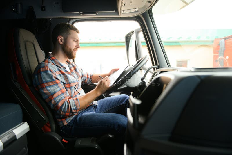 The Truck Driver Looks at the Documents for the Cargo he is ...