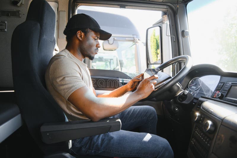 Truck Driver Sitting in Truck, Holding Tablet, Looking at Cargo Details ...
