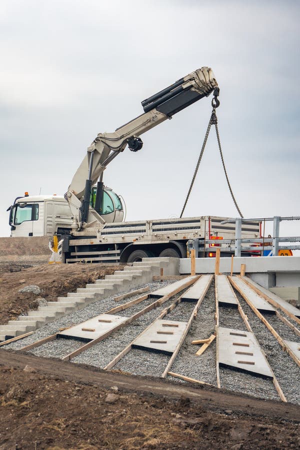 A Truck with a Telescopic Crane Unloads Building Materials at a ...