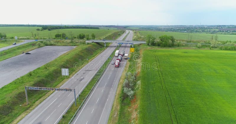 Trucks Rides on Modern Highway Around Green Grass Top View. Trucks on ...