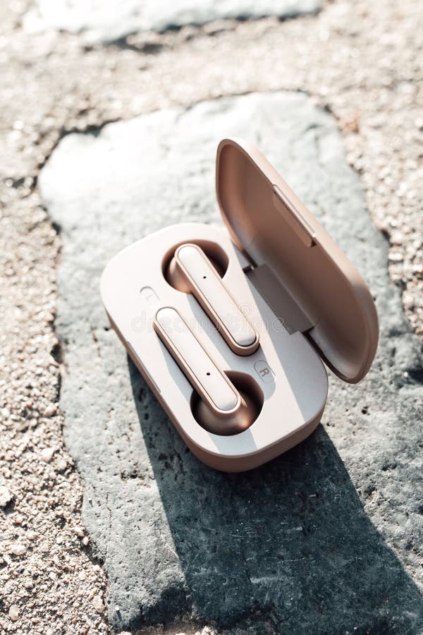 True Wireless Earbuds in Case on Natural Stone Background, Top View ...