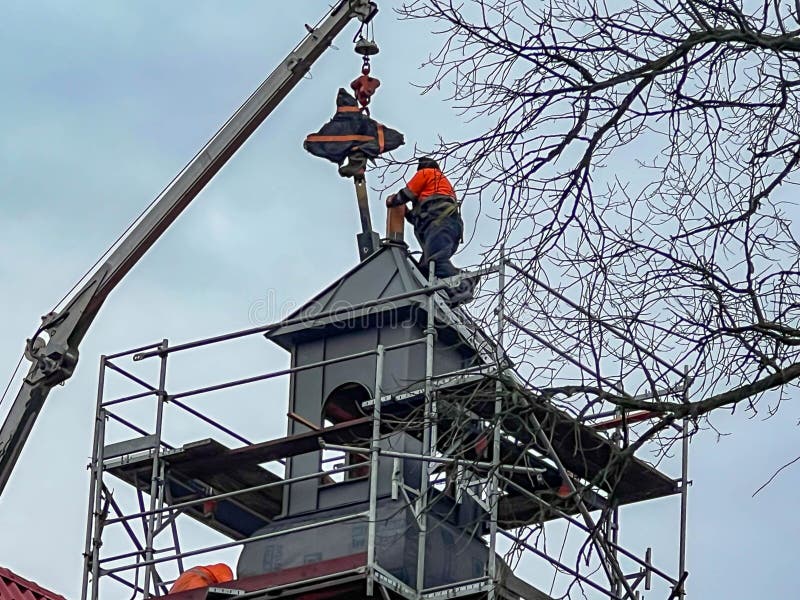 Trying on, Adjusting the Cross on the Tower of the Renovated Church ...