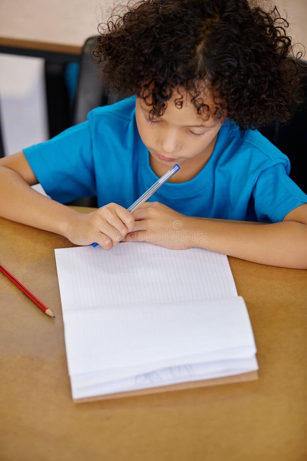 Trying To Find the Answer. a Young Ethnic Boy Sitting in a Classroom ...