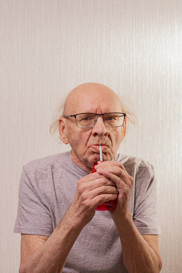 Old Man Drinks through a Tube of Liquid from a Red Jar of Under the ...