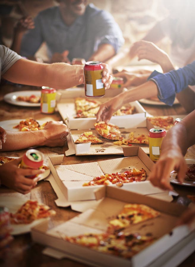 Tuck in. a Group of Friends Enjoying Pizza Together. Stock Image ...