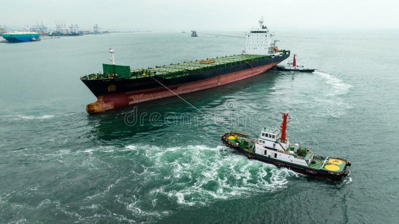 Tugboat Dragging Cargo Ship in Green Sea Stock Image - Image of ...