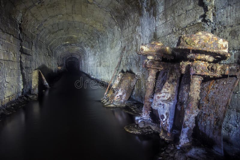 The Tunnel of an Old Abandoned Mine with Rusty Remnants of Trolleys ...