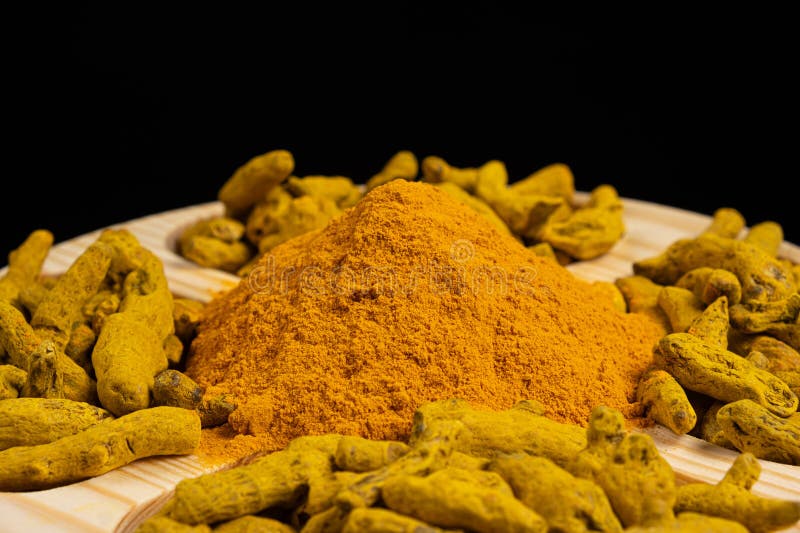 Turmeric Powder and Dried Turmeric Root on a Black Background Stock ...