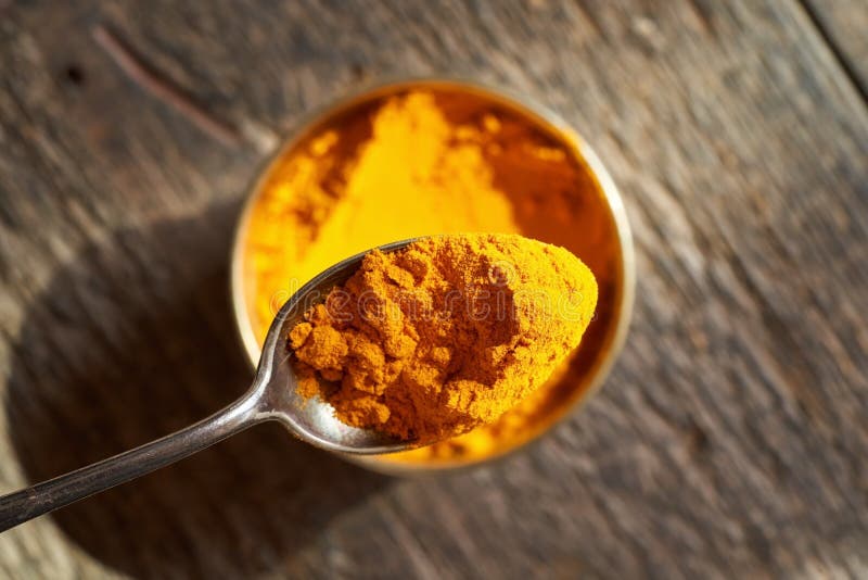 Turmeric Powder on a Spoon Above a Bowl on a Table Stock Image - Image ...