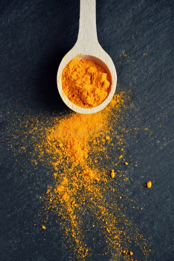 Turmeric Powder in the Wooden Spoon on Black Slate Stock Image - Image ...