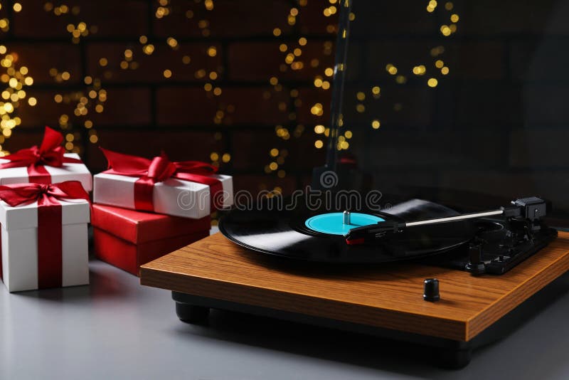 Turntable with Vinyl Record and Christmas Gift Boxes Against Blurred ...