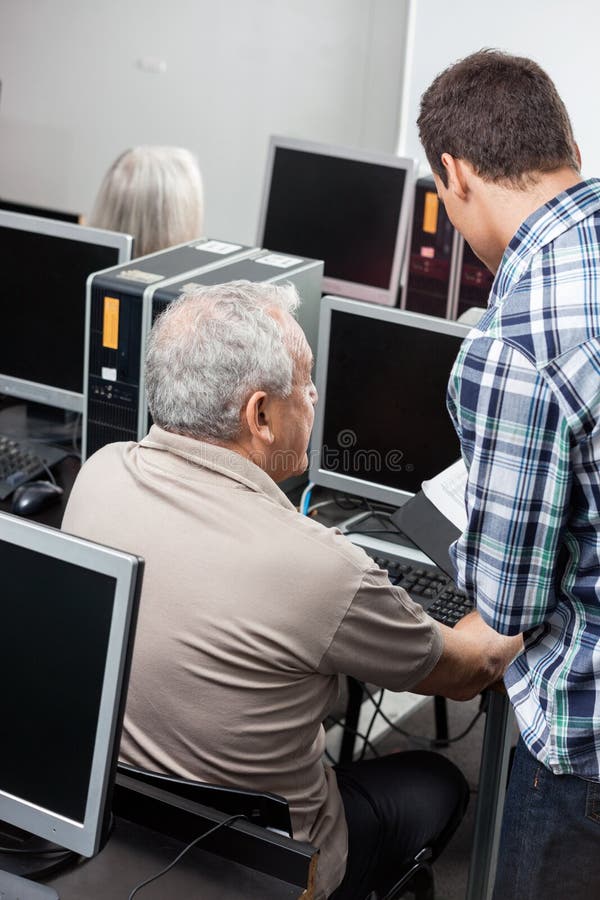 Tutor Assisting Senior Man in Using Computer at Classroom Stock Image ...