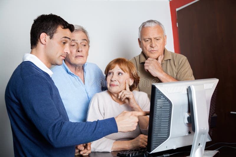 Tutor Assisting Senior People in Using Computer at Classroom Stock ... Tutor Assisting Senior People in Using Computer at Classroom Stock ...