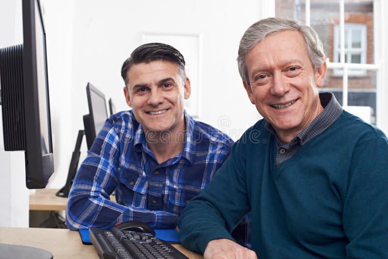 Tutor Helping Mature Man in Computer Class Stock Photo - Image of ...