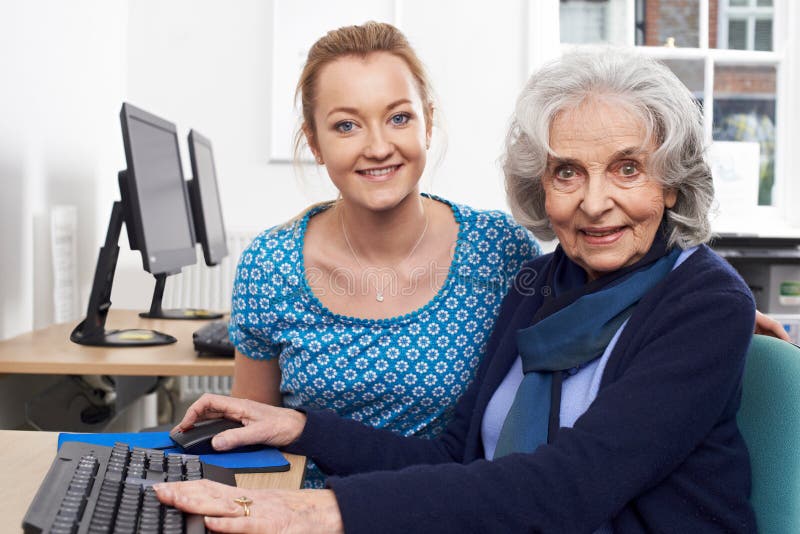 Tutor Helping Senior Woman in Computer Class Stock Photo - Image of ...