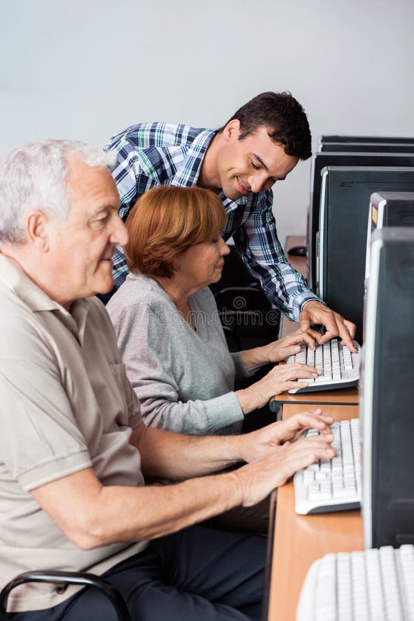 Tutor Helping Senior Woman in Using Computer Stock Photo - Image of ...