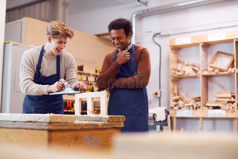 Tutor with Male Carpentry Student in Workshop Studying for ...