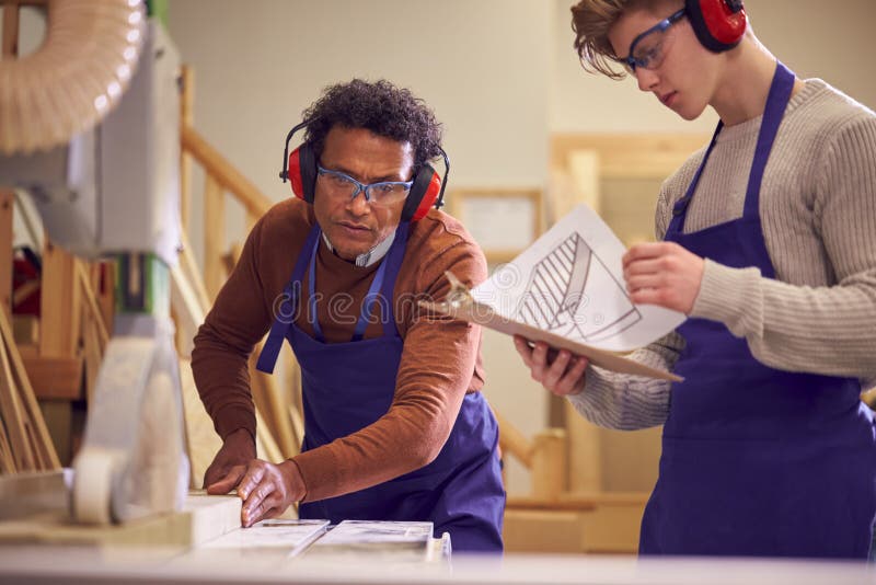 Tutor with Male Carpentry Student in Workshop Studying for ...
