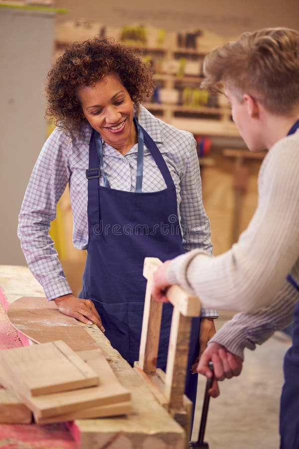 Tutor with Male Carpentry Student in Workshop Studying for College ...