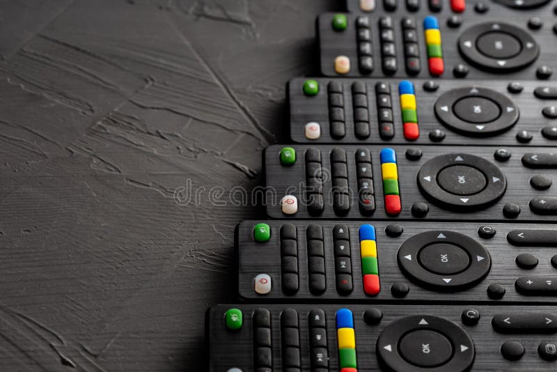 TV Remotes are Stacked in a Row on a Dark Background Stock Photo ...