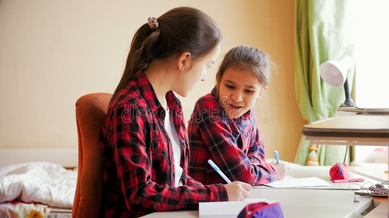 Portrait of Twe Smiling Girls Talking while Doing Homework Stock Image ...