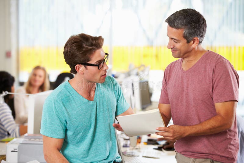 Twee Mensen Die in Creatief Bureau Samenkomen Stock Afbeelding - Image ...