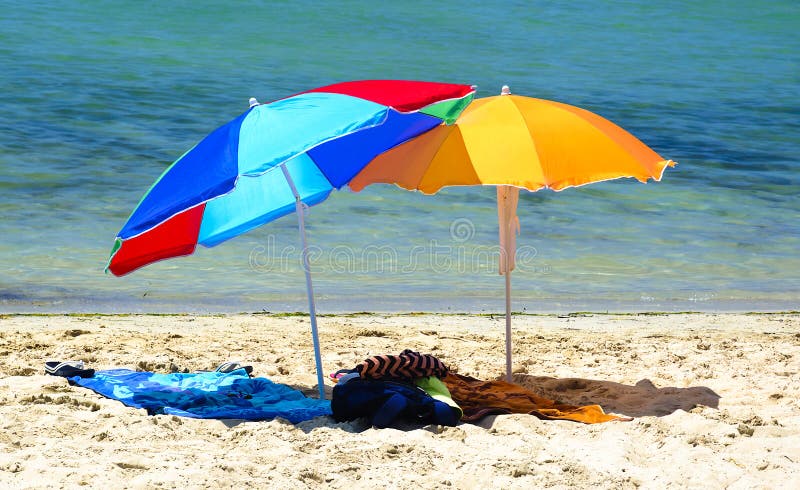 Twee Kleurrijke Parasols Op Strand Door Het Overzees Stock Afbeelding ...